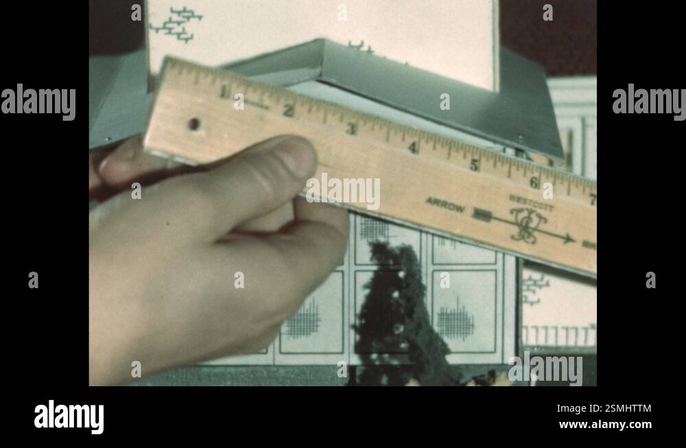 1940s: A hand holds a wooden ruler with an arrow pointing to the right ...