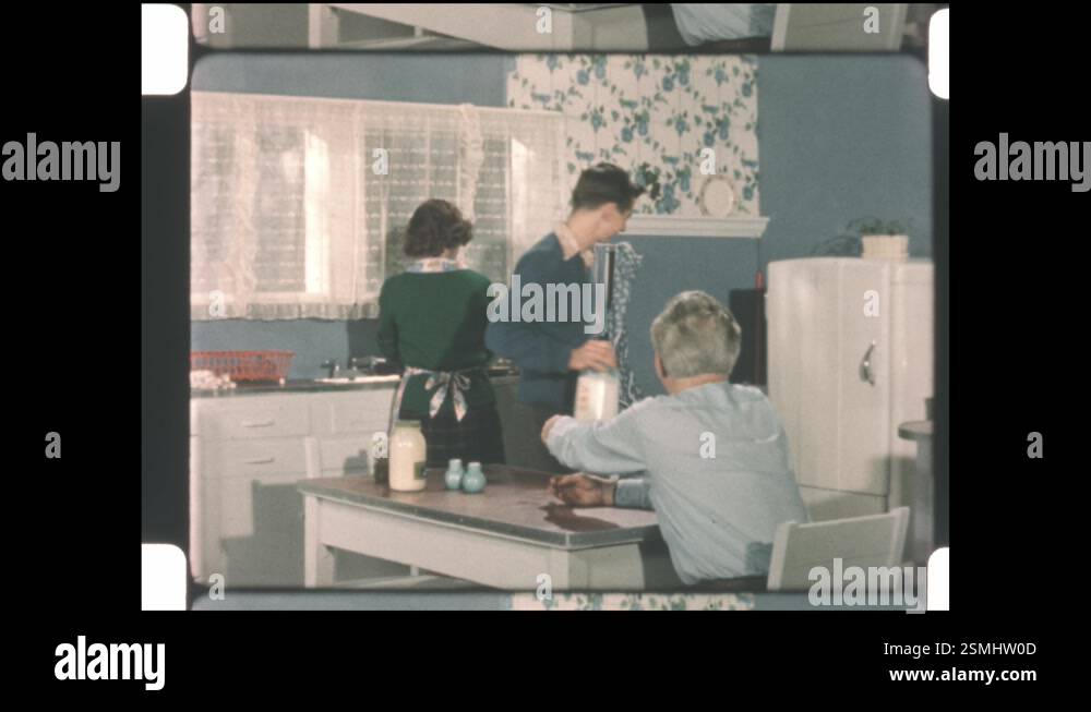 1950s: Girl slaps clapper and speaks. Boy and girl put away breakfast ...