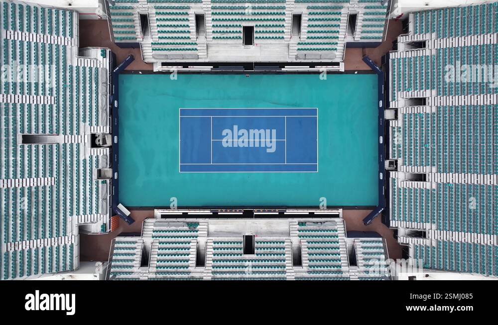 Empty tennis court in a large outdoor stadium. Symmetrical seating ...