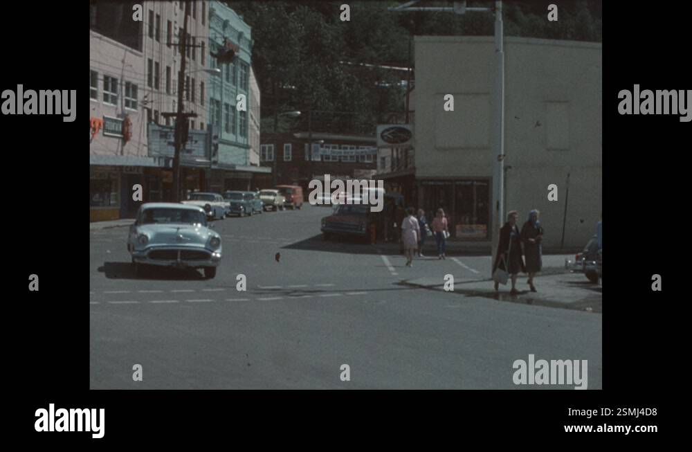 1960s: A bustling downtown street scene in the 1950s. Cars drive down ...