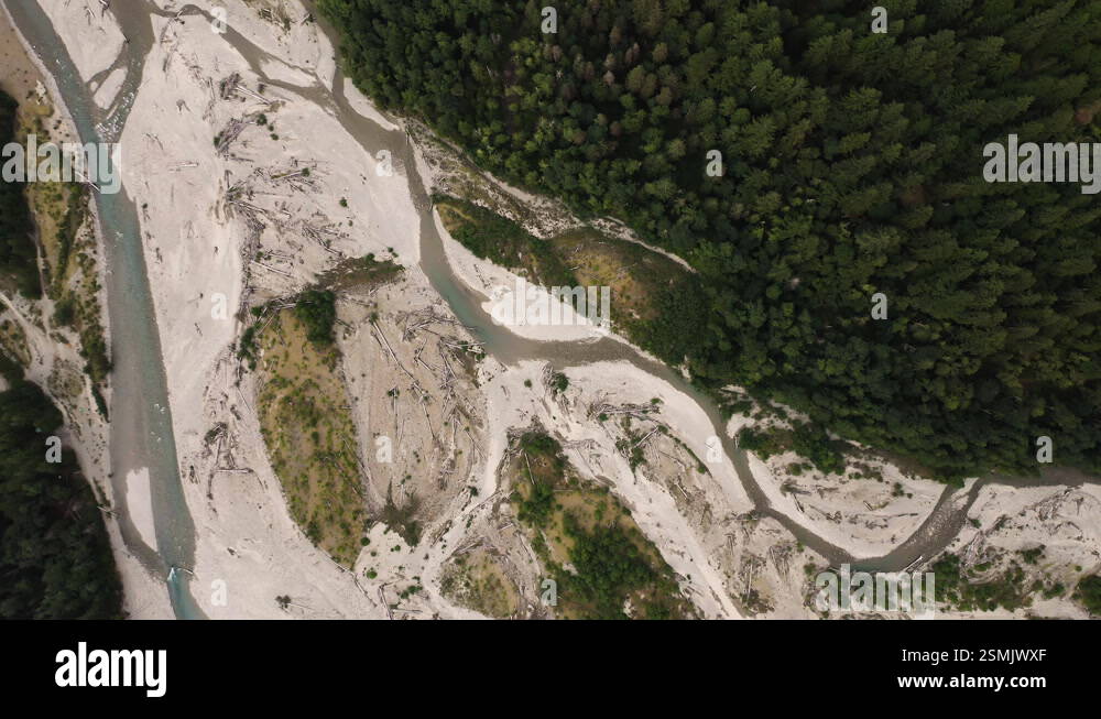 Drone top down of meandering floodplain river below evergreen forest ...