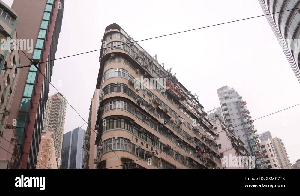Tall curved building with multiple floors and crowded balconies in a ...