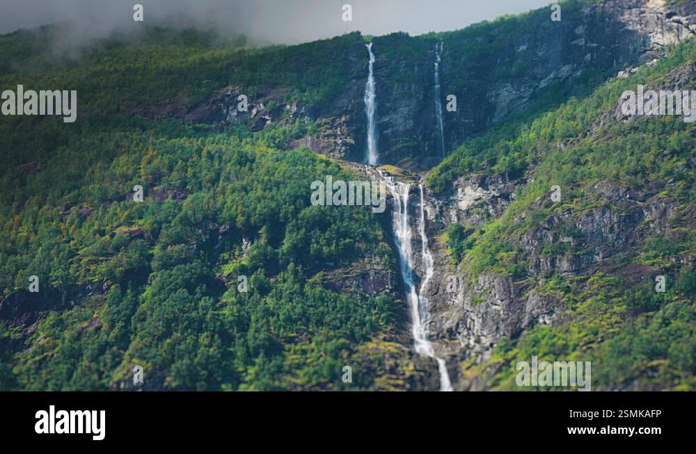 Two-tier waterfall on the forest-covered cliffs above the Loenvatnet ...