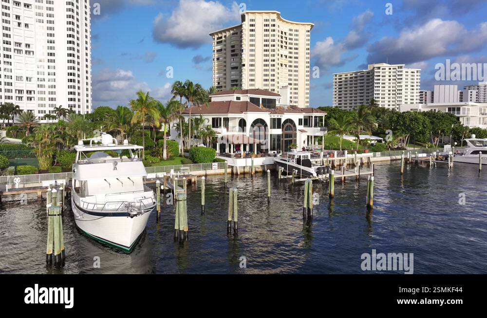 Yacht docked by luxury waterfront mansion in Florida. High-rise ...