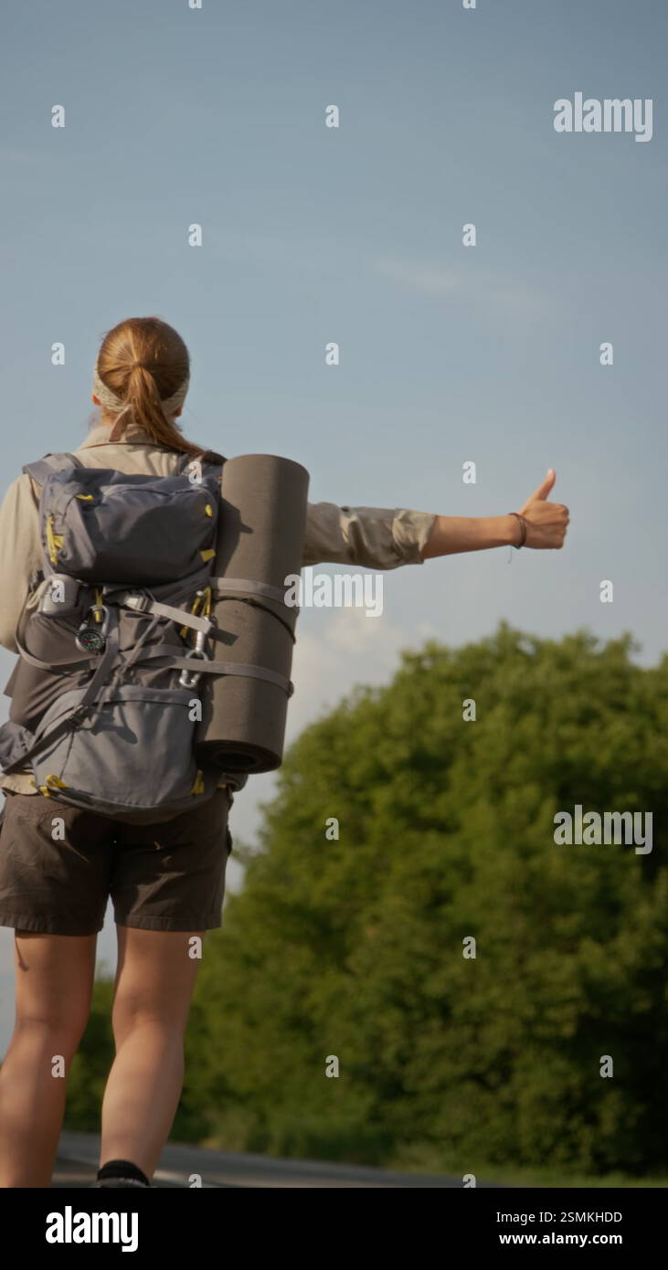 Female Hitchhiker with Backpack Walking by Country Road and Raising ...