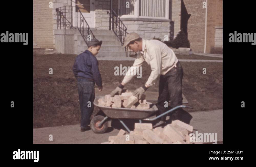 1950s: Sidewalk in front of house. Man and boy load bricks into wheelbarrow Stock Video Footage ...