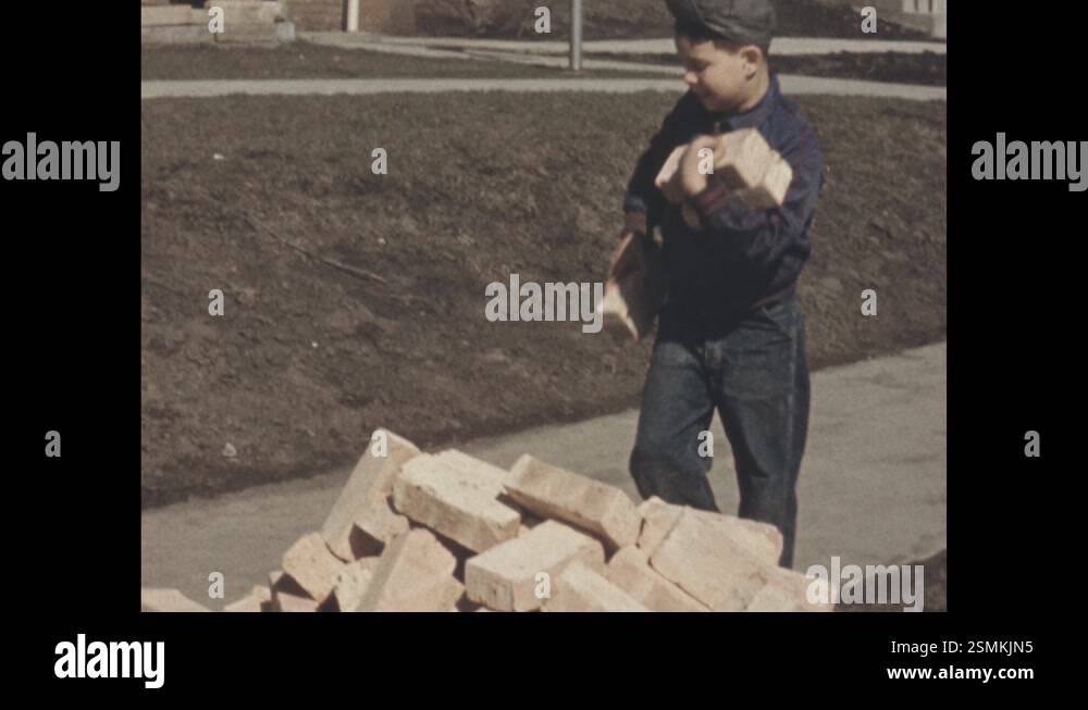 1950s: Little boy picks up bricks and walks around back of house ...