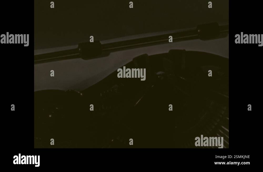 1950s: Boy writing at desk. Paper in typewriter. Boy typing. Hand moves ...