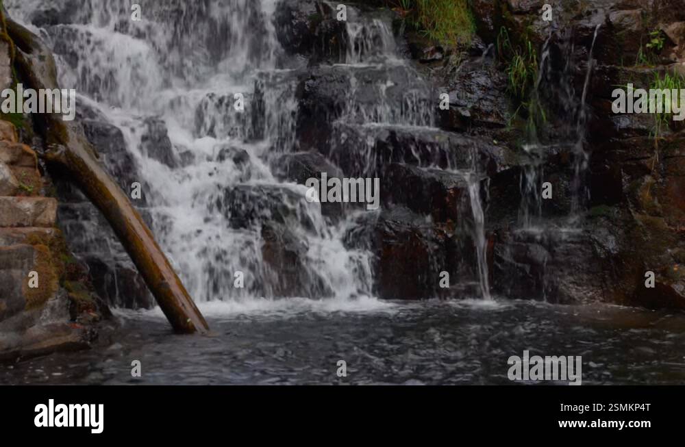 A powerful waterfall cascades into a popular swimming hole in the woods ...