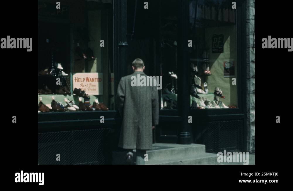 1950s: A storefront window displays a help wanted sign alongside an ...