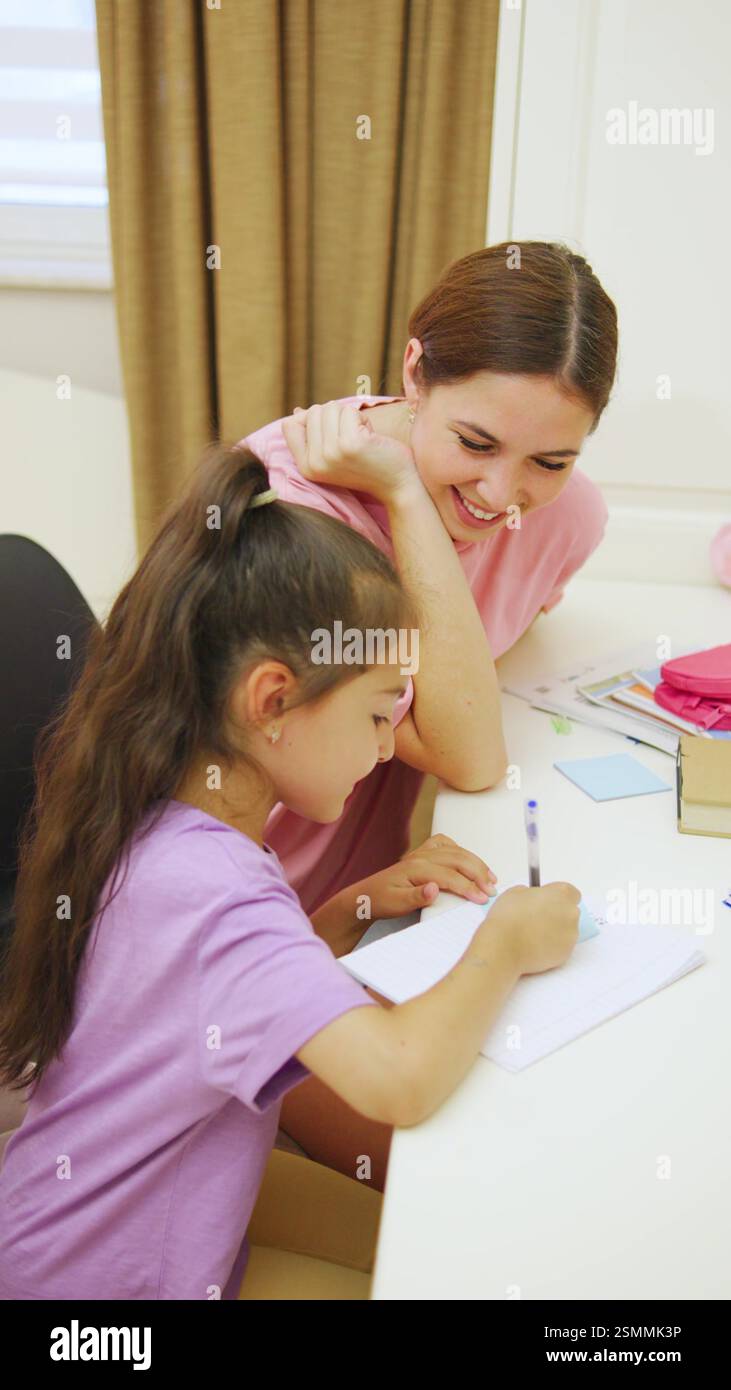 Caring Mother Helps Her Daughter With Her Homework At Home Stock Video
