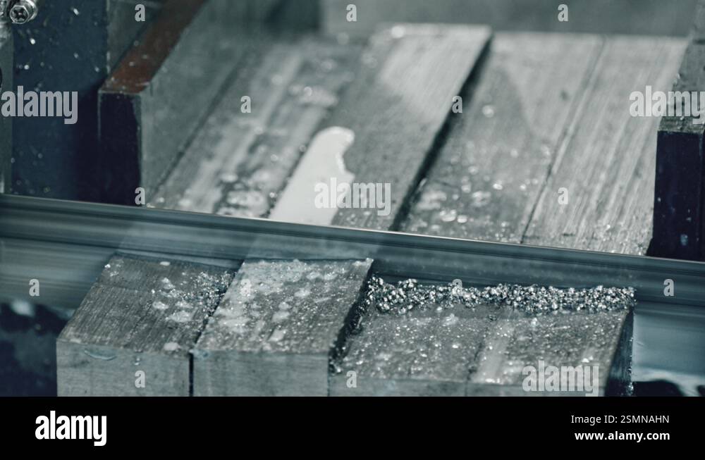 Precision cutting of metal bars with industrial bandsaw and coolant ...