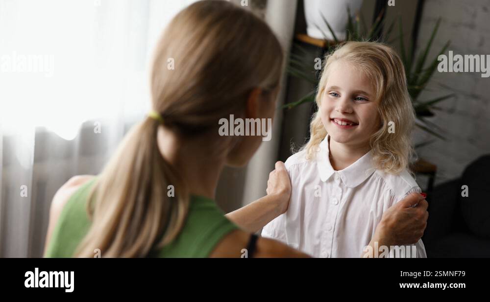 mother helps and support her daughter get ready for first school day in ...
