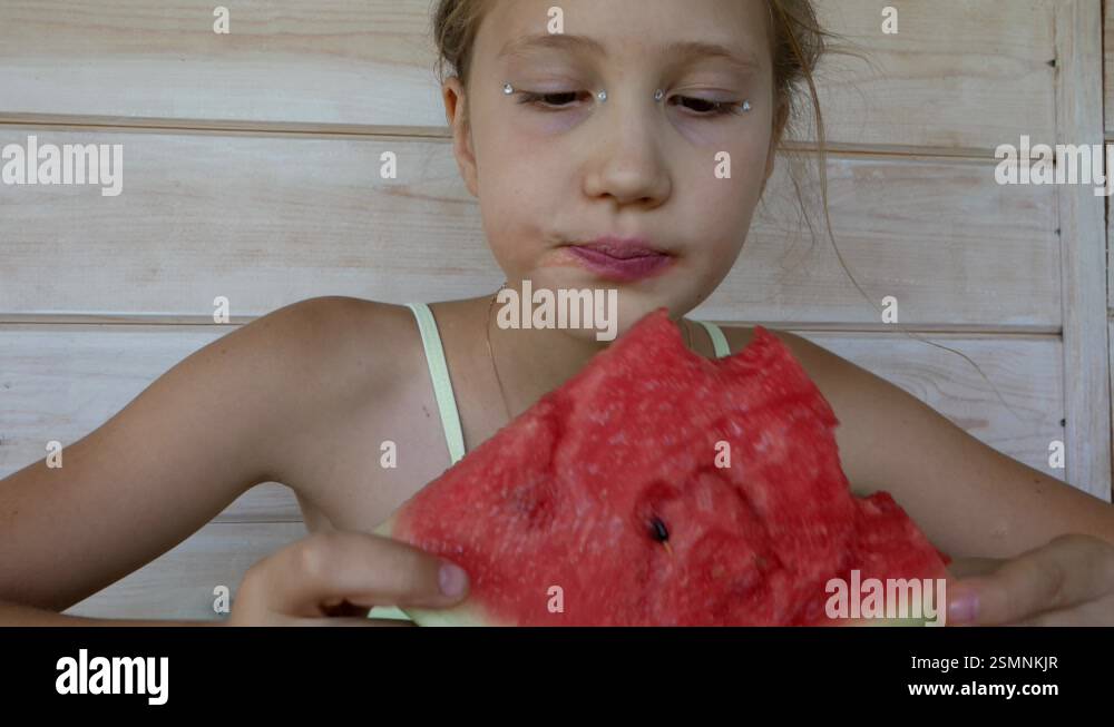 Cute little girl eating a slice of watermelon. Teenage girl bites ...