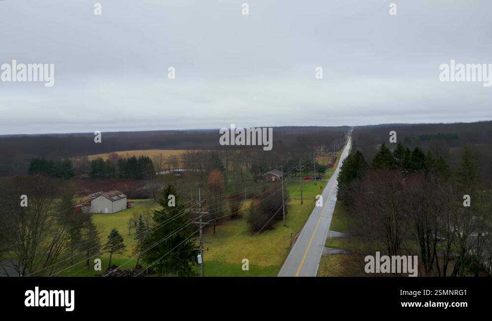 An aerial perspective of a straight country road stretching far into ...
