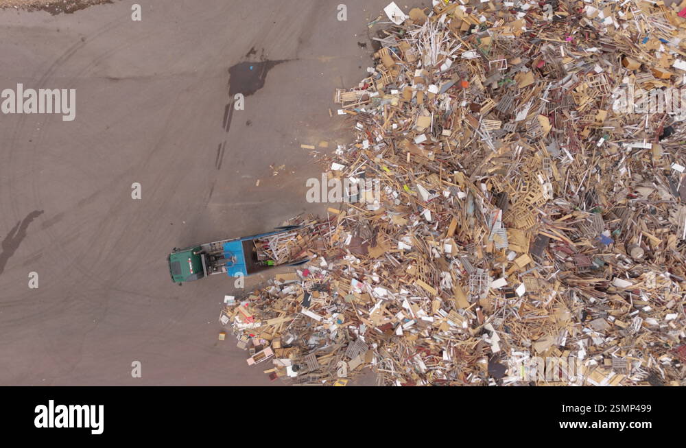 Top-down aerial of truck dumping scrap wood onto pile at recycling ...