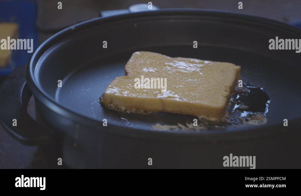 Making French toast being fried in ghee and sugar in a non stick pan ...