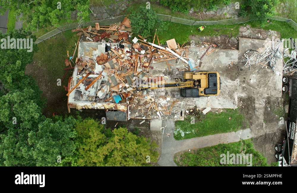 Excavator demolishing house. Ground level demolition with debris ...