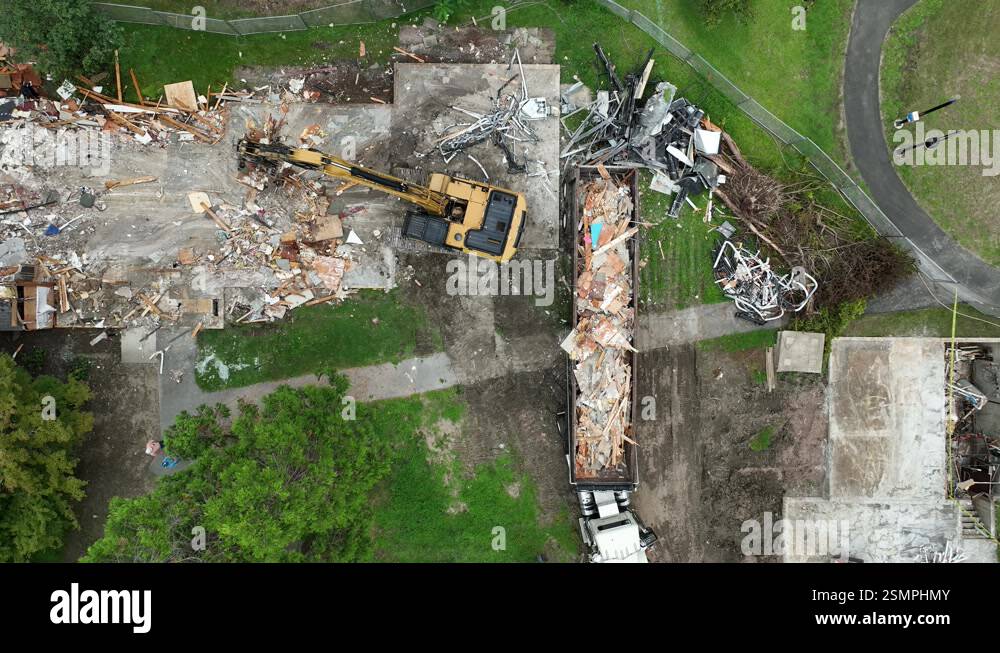 Drone top down static of building demolition as crane claw lifts to ...