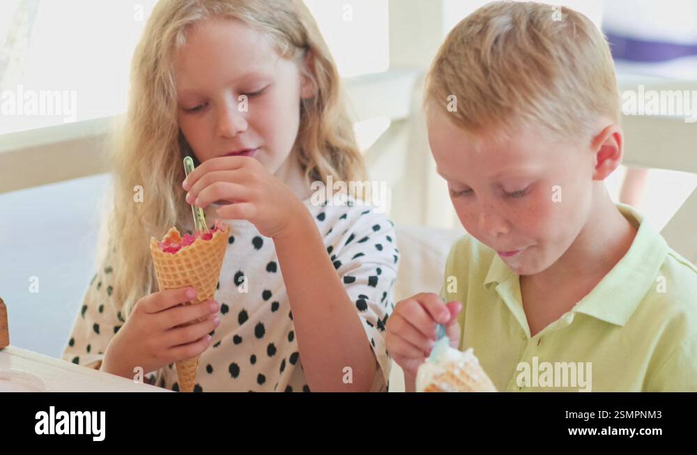 Girl and boy eat and licking ice cream in cone. prescholler friends ...