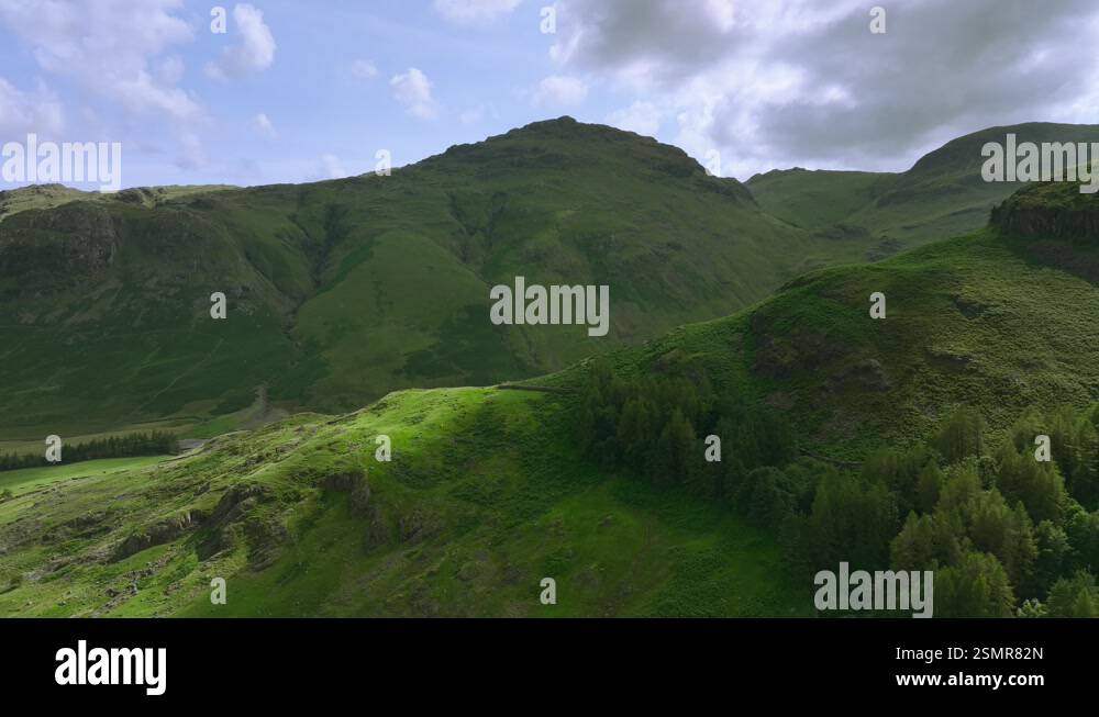 Flying towards shadowed mountain limb and further mountain revealing ...