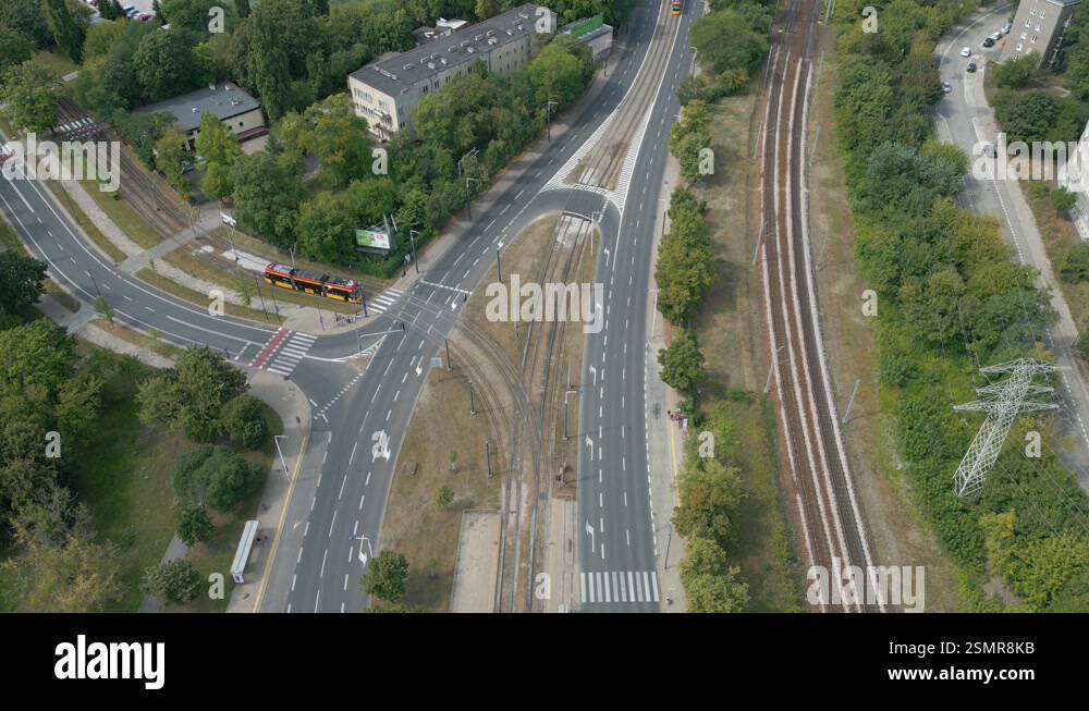 Aerial view of asphalt road junction with electric train tram lines and ...