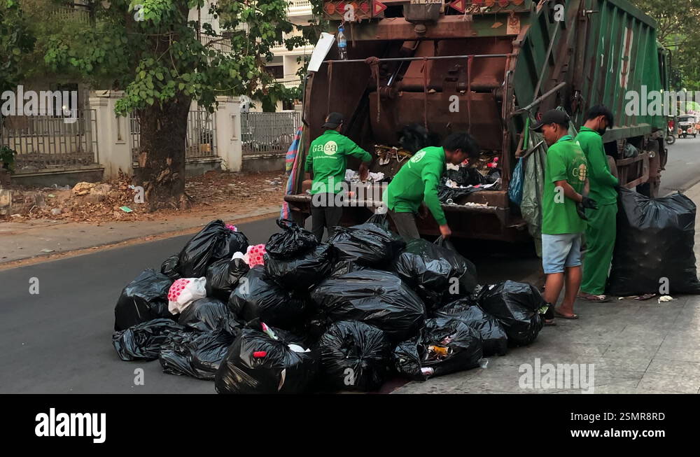 Siem Reap, Cambodia - 04/21/2024: Four garbage men sort and dump ...
