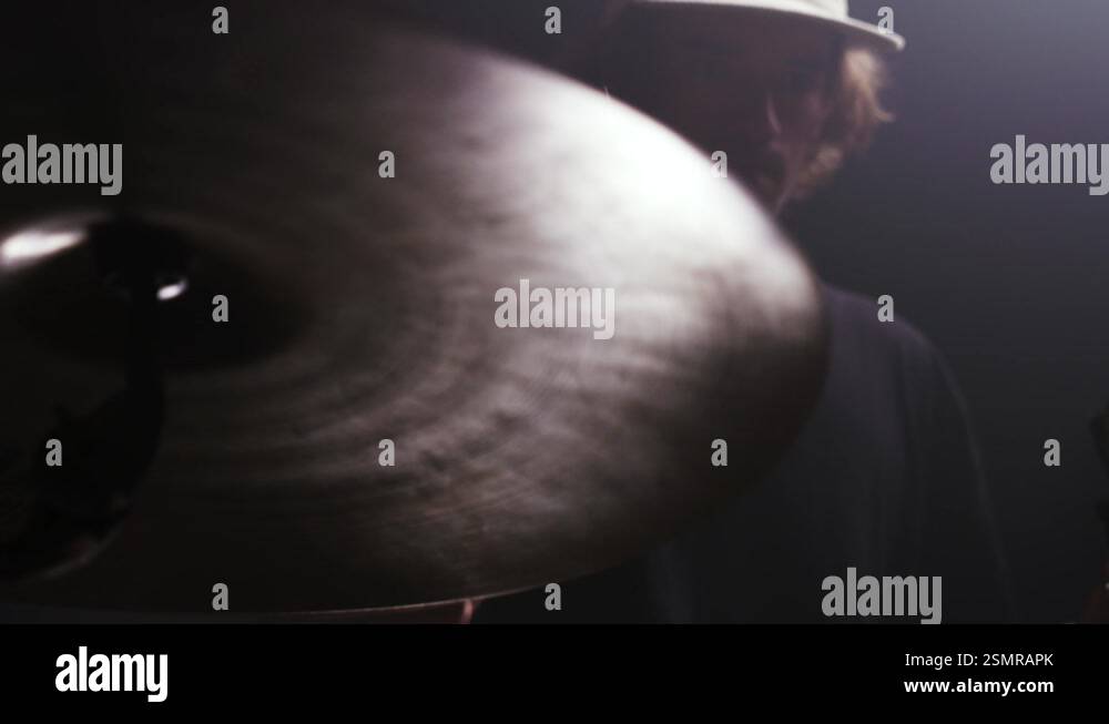 Close up slow motion clip of a vibrating cymbal and the drummer in the ...