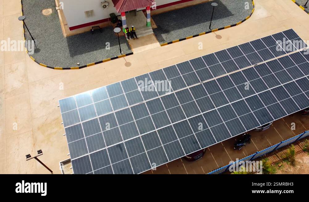 Aerial dynamic tilt up overview of solar car shed, PV power plant and ...