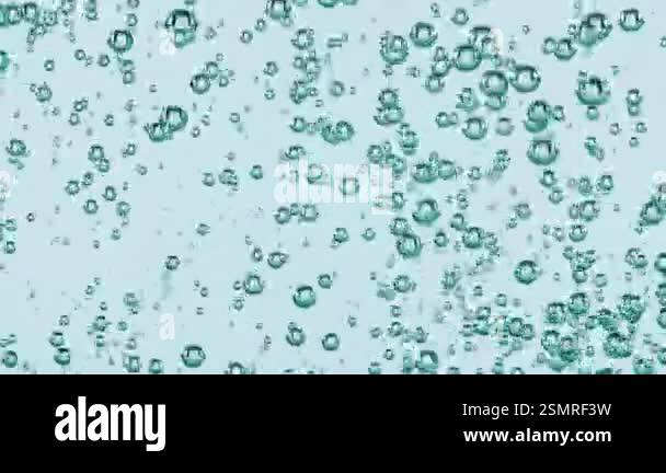 Macro shot of air bubbles in water rising up on light blue background ...