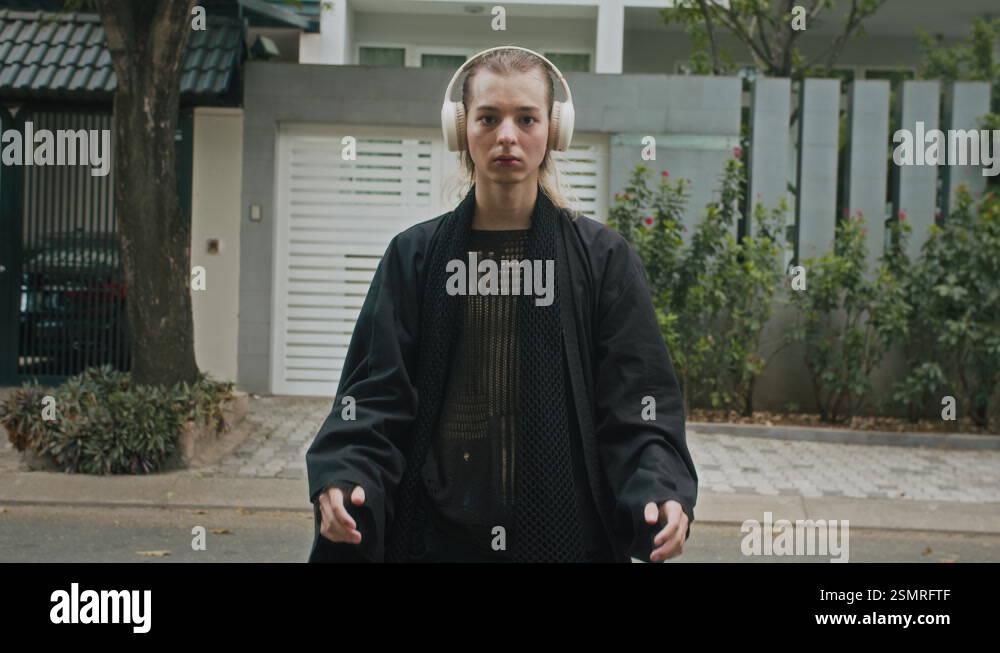 Chic Serious Male Zoomer in Black Clothes Wearing Headphones Outdoors ...