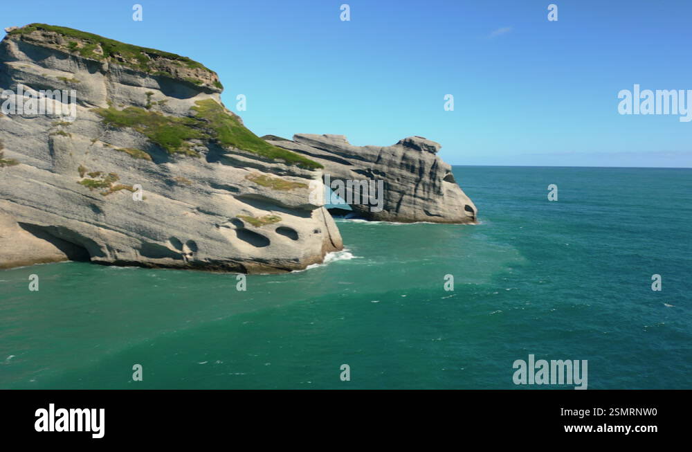 Low flight around tip of sea stack revealing arched stack and Whareriki ...