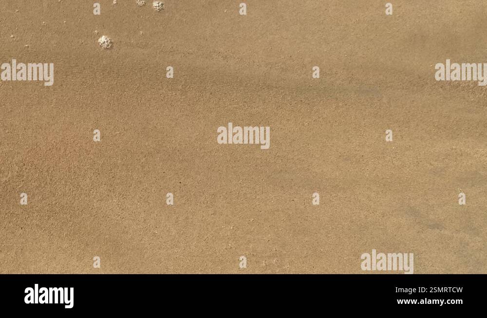 natural sand beach background being washed over by a wave Stock Video ...