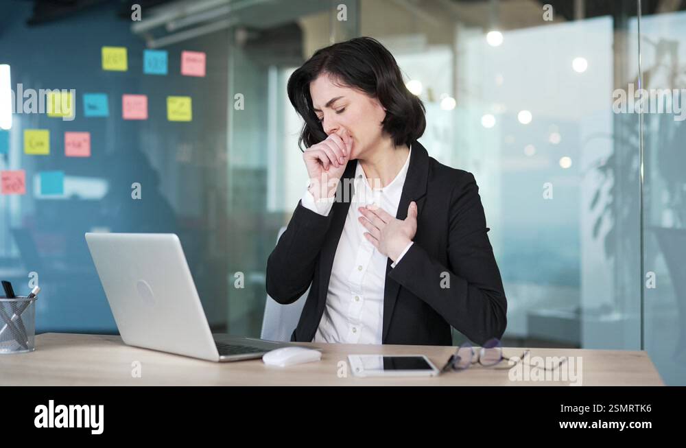 Female office worker suffering from cough and cold during work hours ...