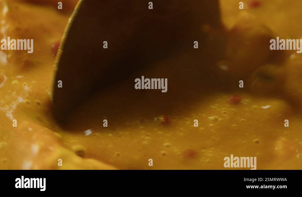 Yellow boiling sauce on pan close-up. Asian cuisine concept. Curry is a ...