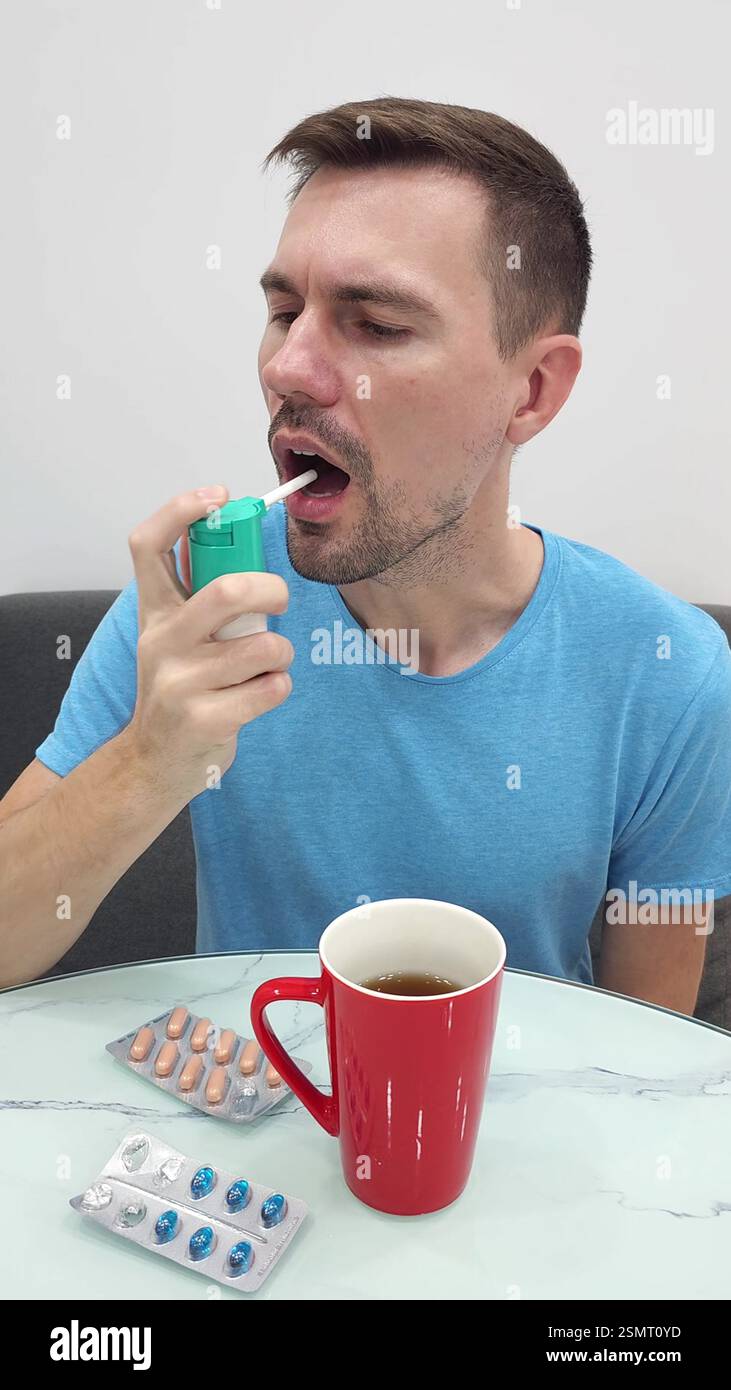 White man using inhaler and red mug and blister packs of pills Stock ...