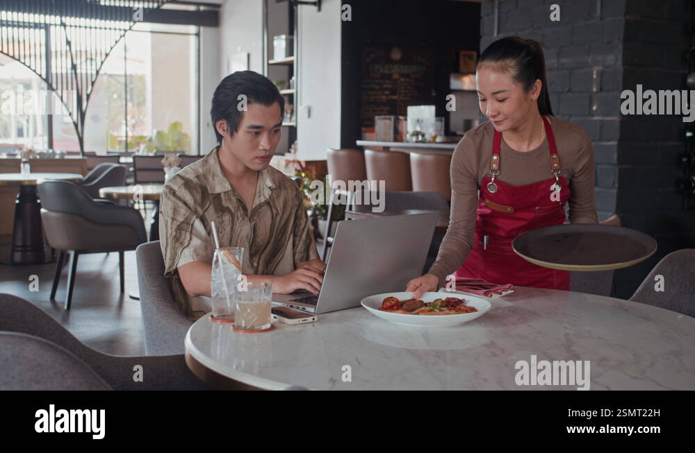 Cheerful Waitress Bringing Plate of Food to Businessman Working at ...