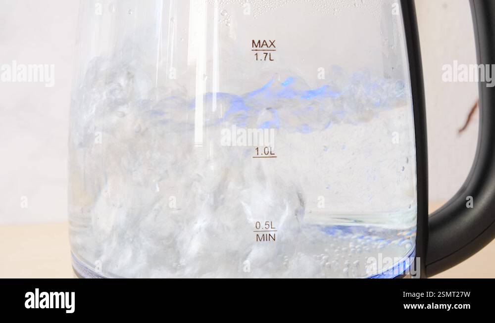 Blurry bubbles in hot water boiling inside glass teapot . Close-up of ...