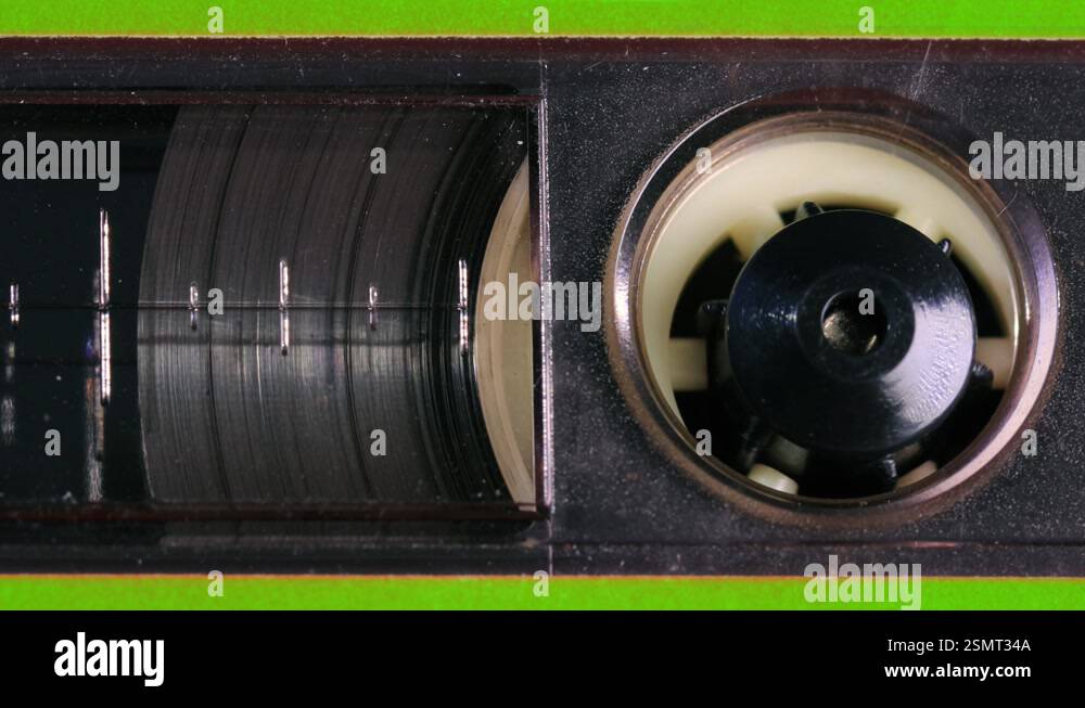 Nostalgic audio cassette tape unwinds behind a transparent window in ...