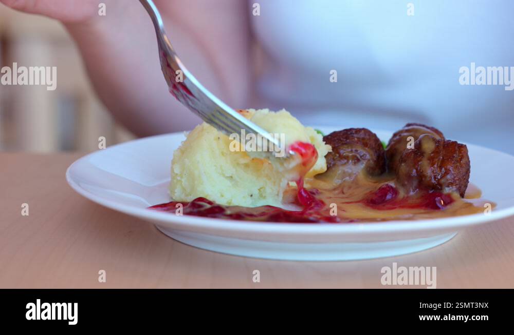 Woman eating swedish meatballs from plate in food court Stock Video ...