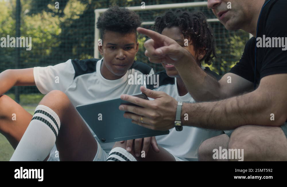 Soccer Coach Discussing Game Strategy with Young Players on Field Stock ...