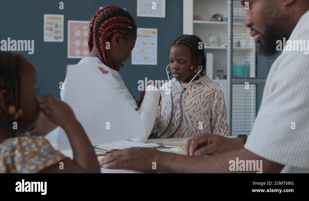 Doctor Teaching Little Girl to Use Stethoscope at Family Appointment ...