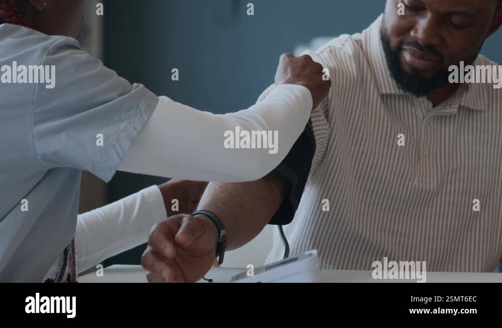 Physician Applying Cuff of Blood Pressure Monitor to Mans Arm Stock ...