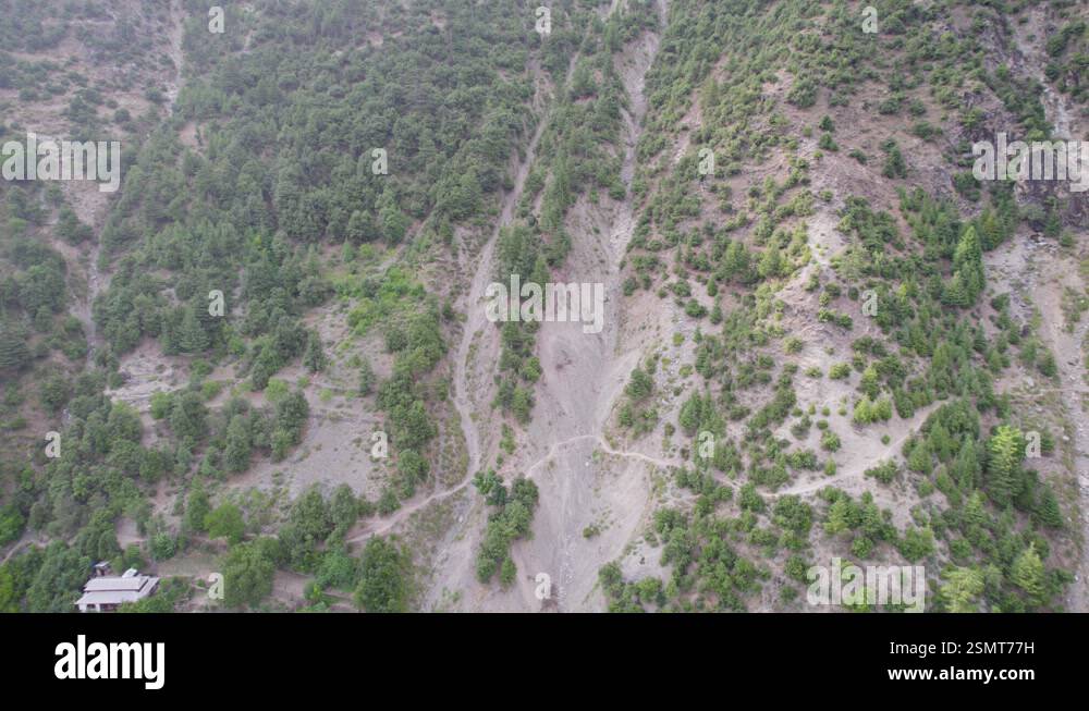 eroded mountain slopes showing landslide scars and sparse vegetation in ...