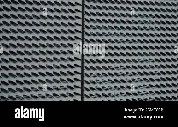 Close-up of a modern buildings facade with a repetitive geometric metal ...
