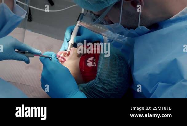 Dentist making tooth cleaning for patient in dental modern clinic ...