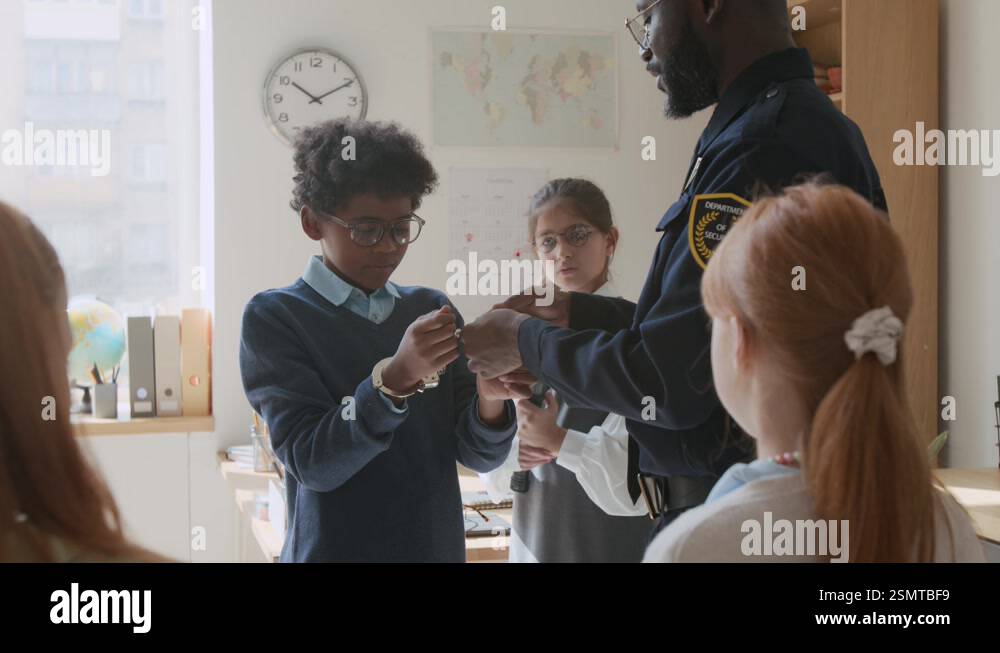 Black Policeman Letting Kids Play with Torch and Handcuffs on Career ...