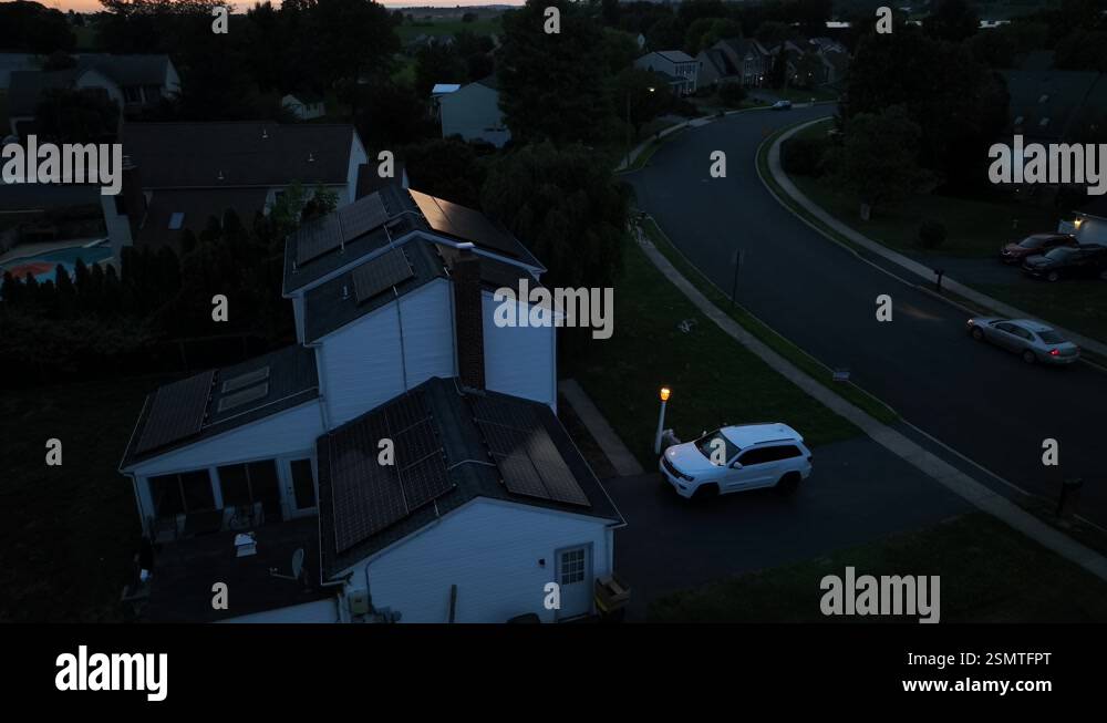 Aerial tilt up of modern housing area with solar panels at roof during ...