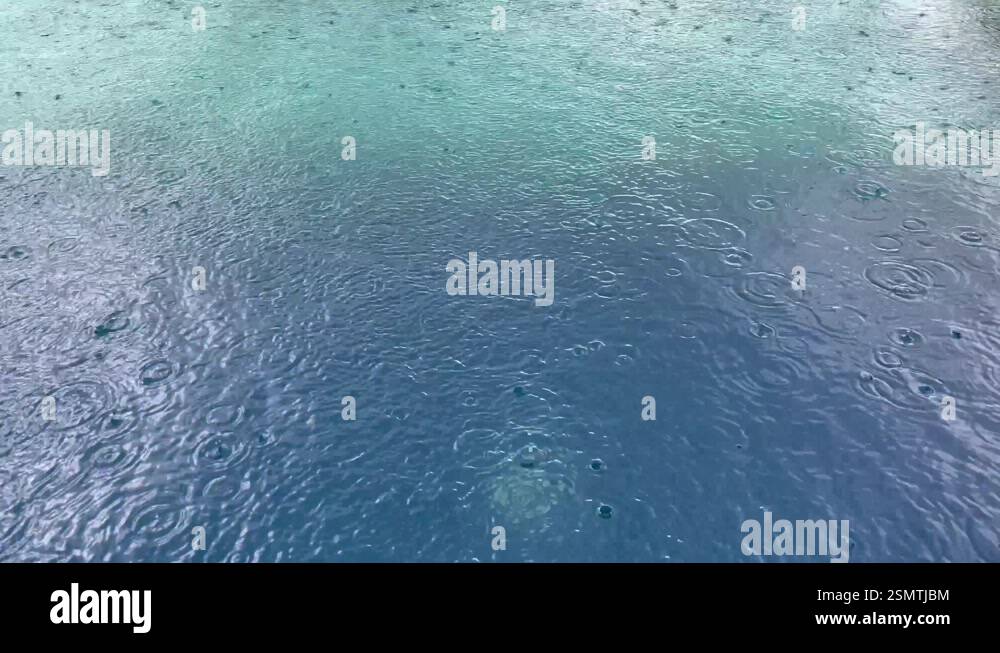 Rain drops falling onto the surface of a swimming pool Stock Video ...