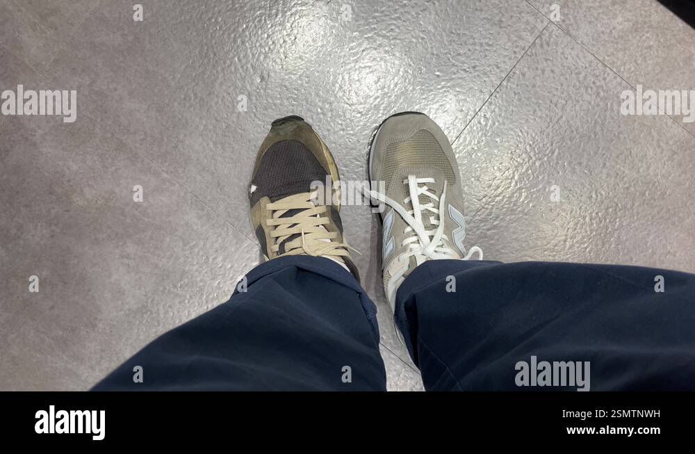 POV first person looking down at feet trying on sneakers shoes. Old and ...